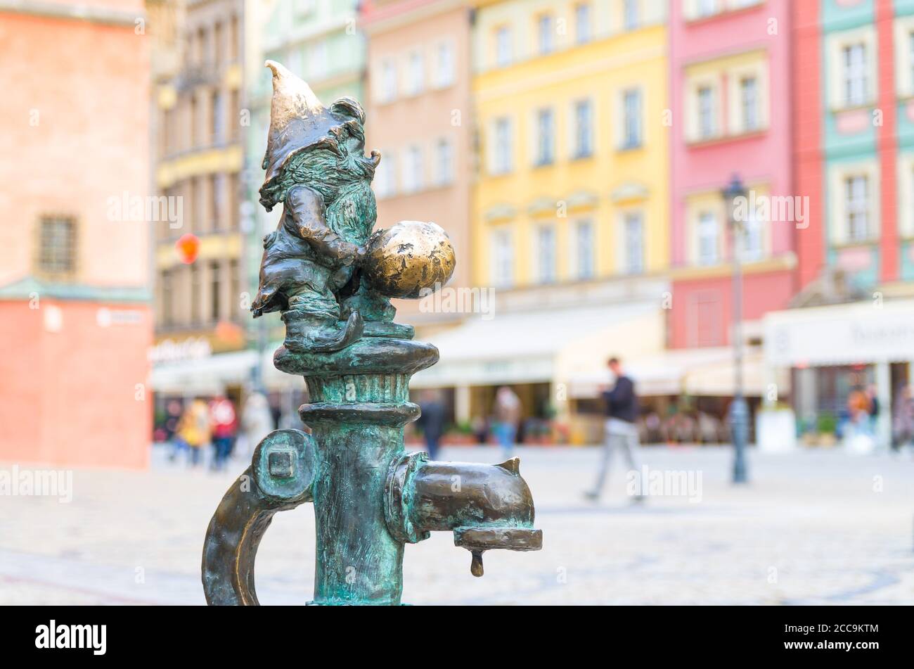 Wroclaw, Poland, May 7, 2019: Dwarf is sitting on street water tap on ...