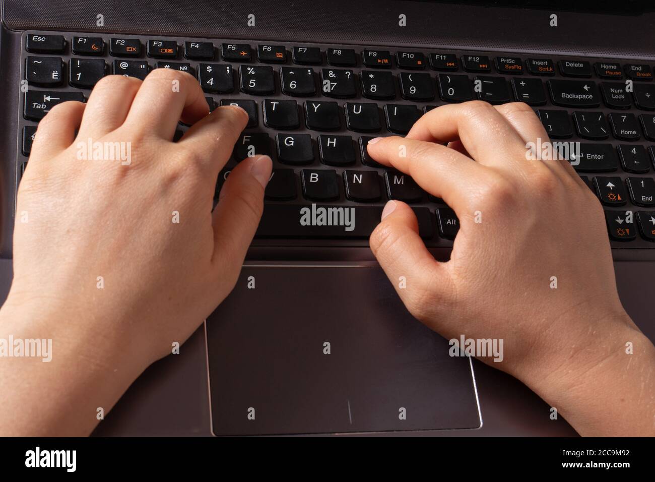 Human hands are typing text on a black laptop keyboard Stock Photo - Alamy