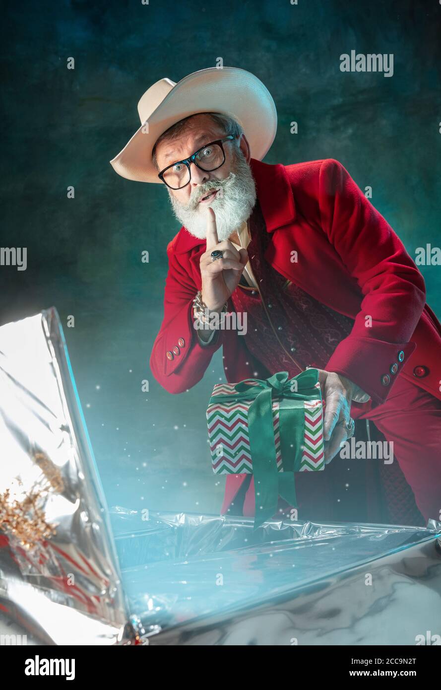 Santa's offers. Modern stylish Santa Claus in red fashionable suit and ...