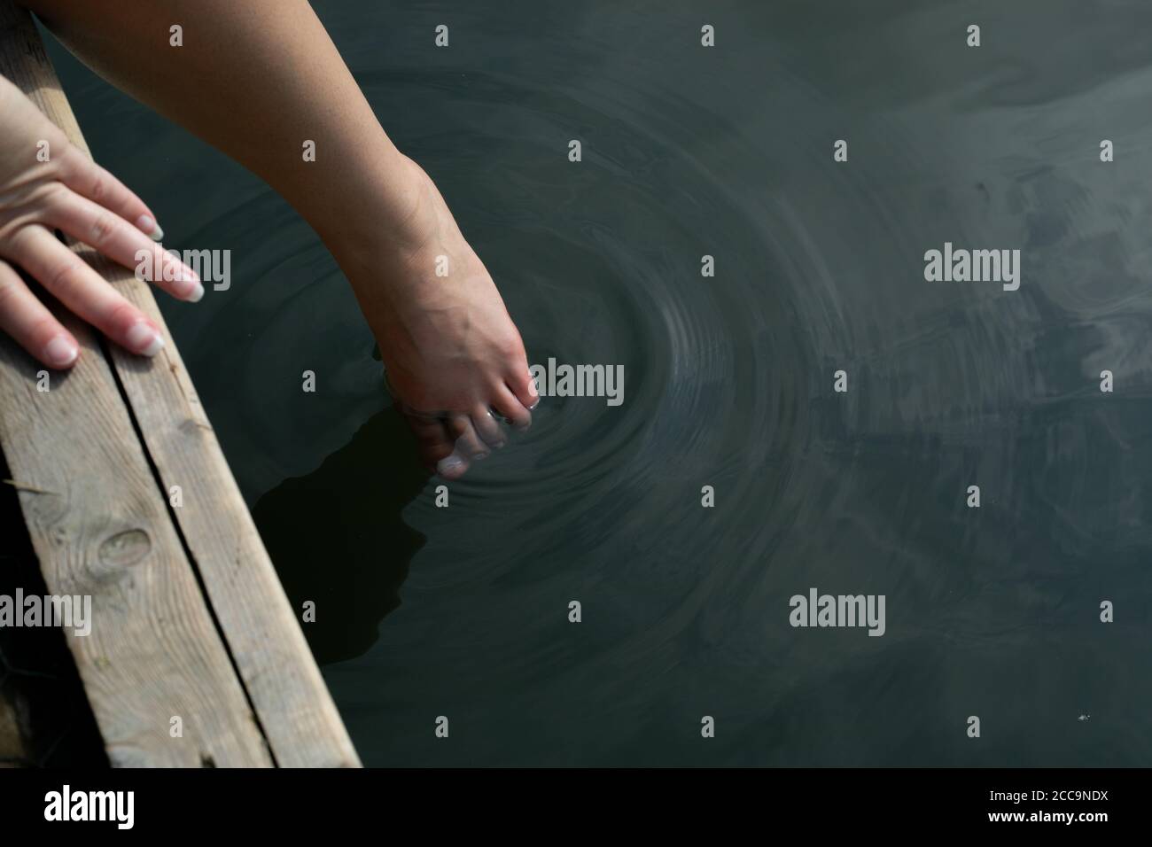 Woman's toes dipping in water Stock Photo - Alamy