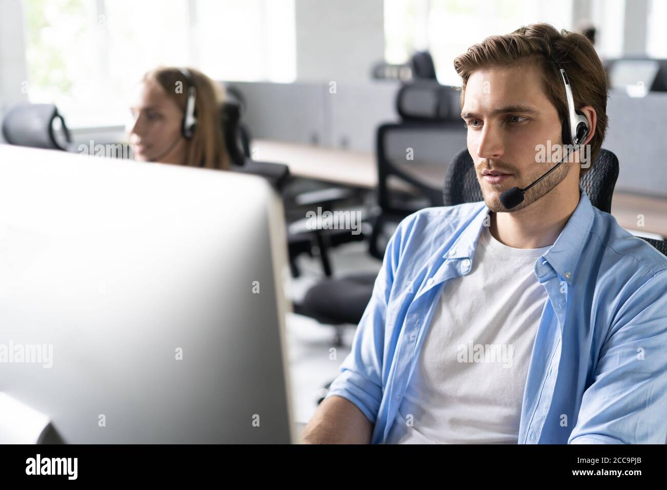 Young handsome male customer support phone operator with headset working in call center Stock ...