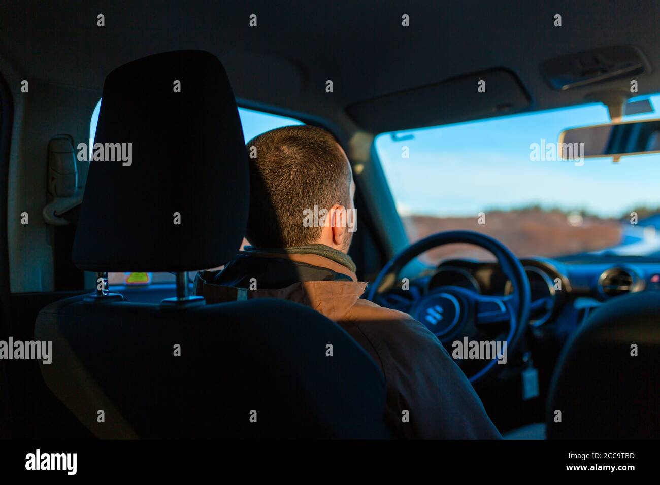 View from the back seat, the guy is driving in the car. Car interior ...