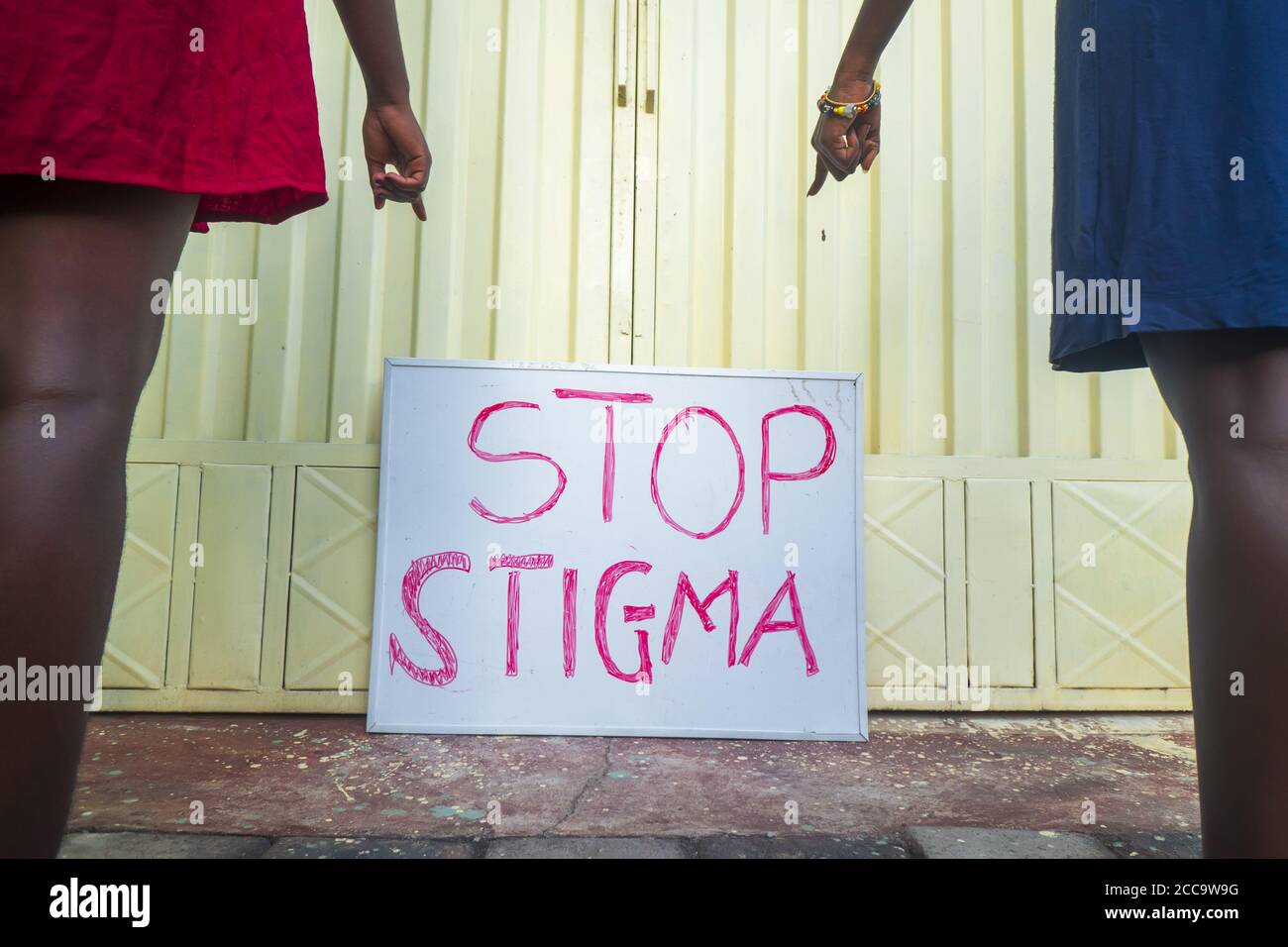 Two black female hands pointing to sign with text "Stop Stigma Stock ...