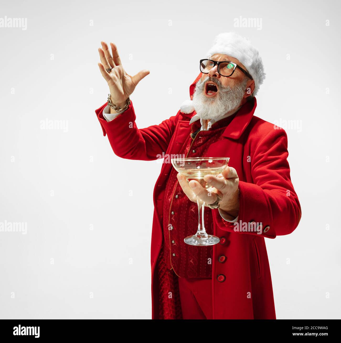 Cheers, toast. Modern stylish Santa Claus in red fashionable suit ...