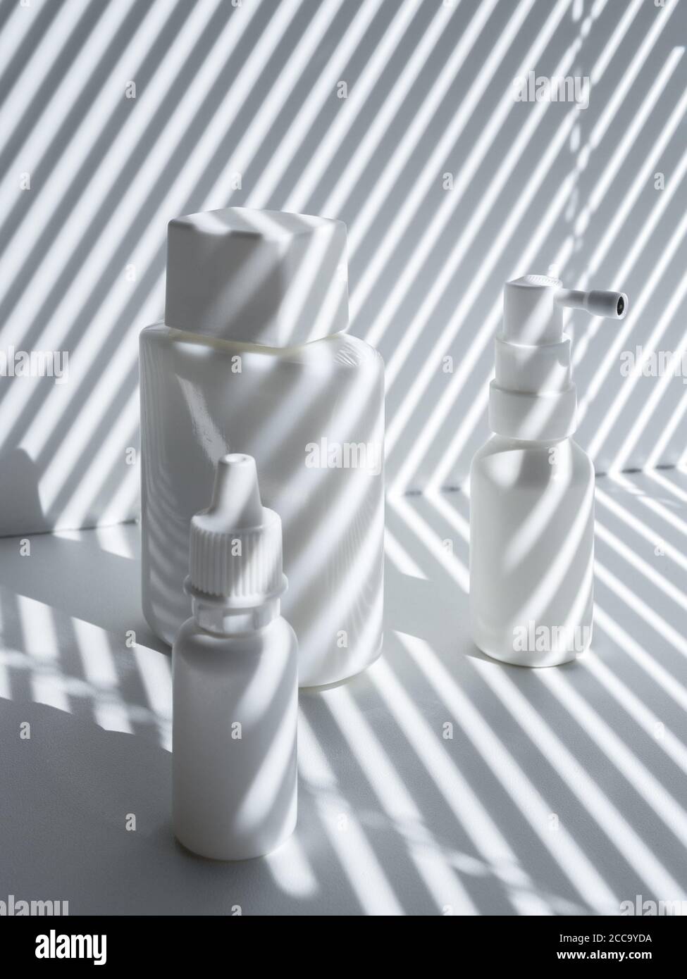 Set of three white vials in rays of the sun Stock Photo - Alamy
