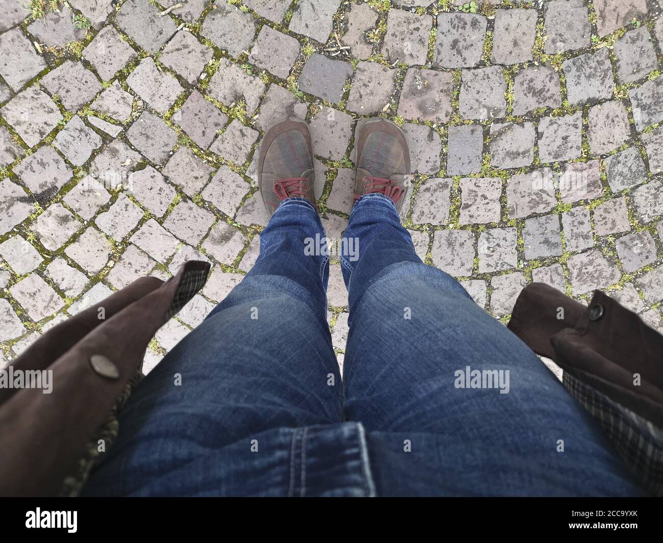 Overhead shot of legs of a man standing on cobblestone pavement Stock ...