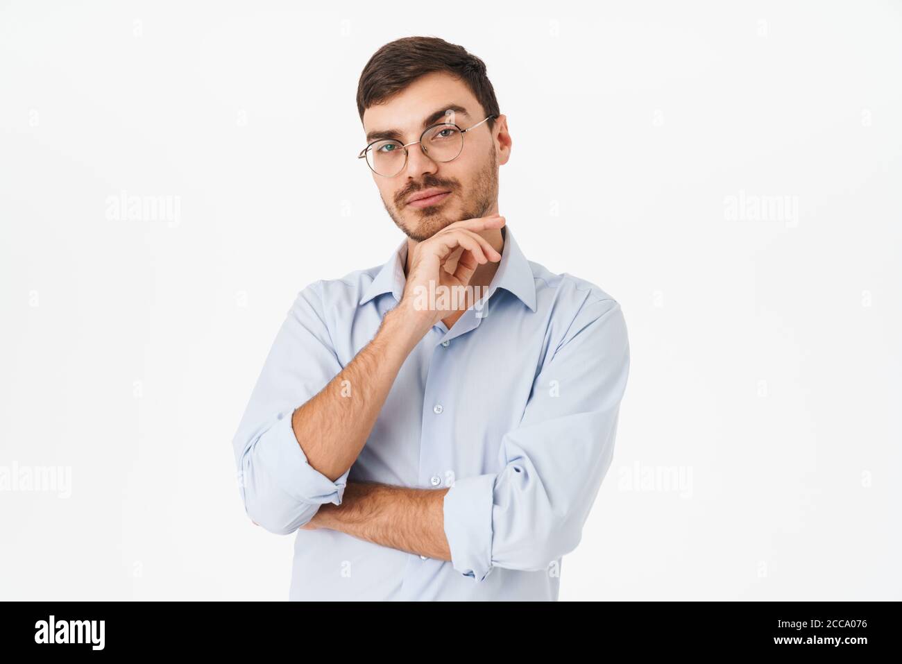 Photo of thinking young man in eyeglasses posing and looking at camera ...