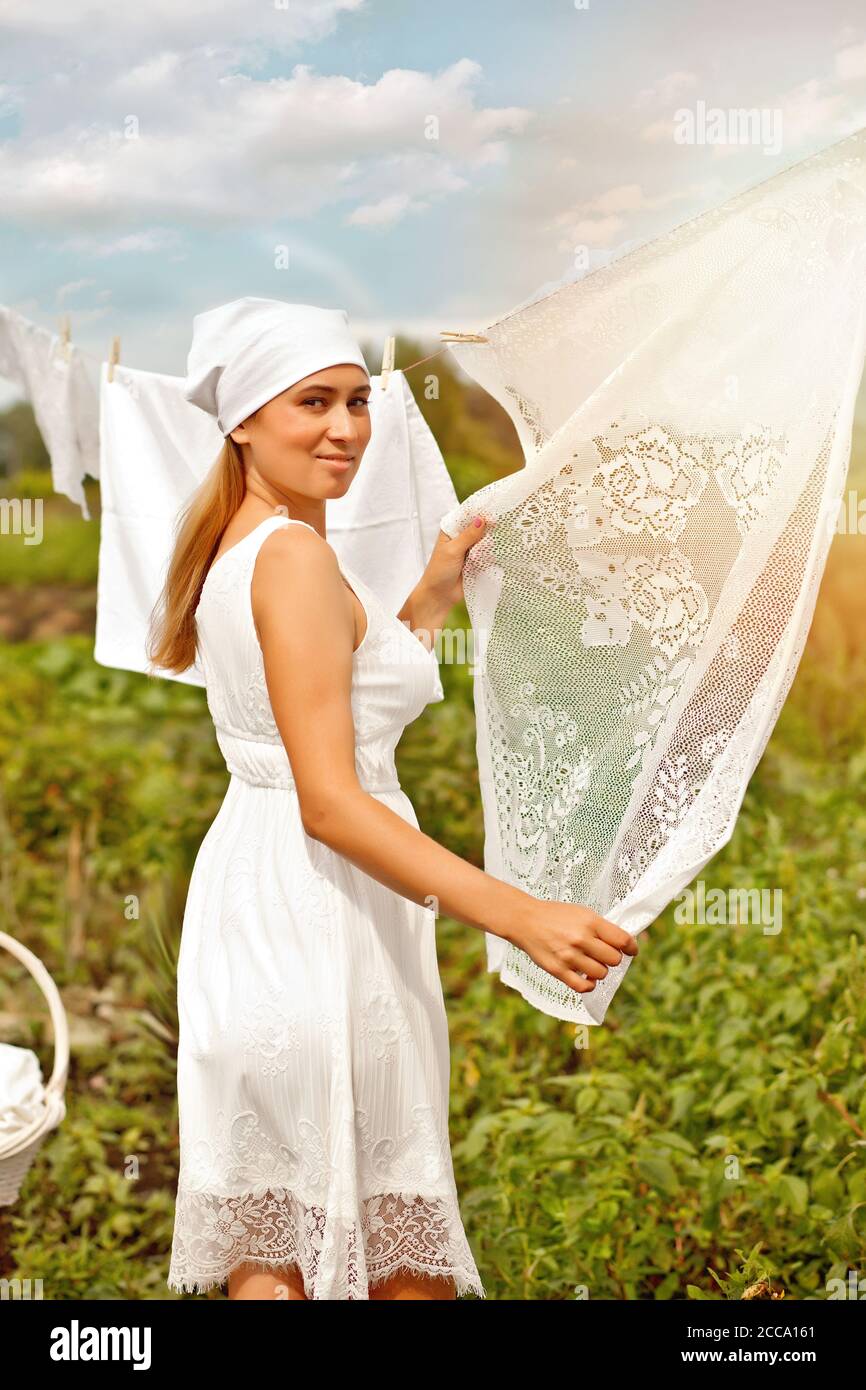 Young woman hanging up laundry outdoor Stock Photo - Alamy