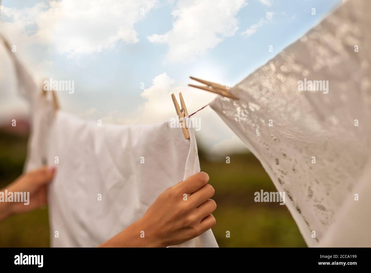 Woman hand hanging up laundry outdoor Stock Photo - Alamy