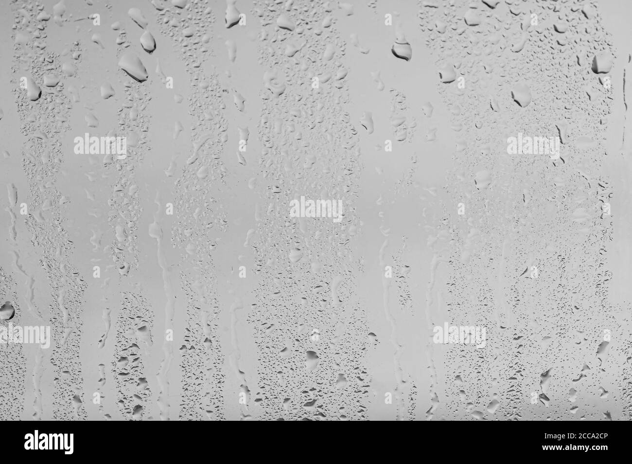 Rain drops on window glasses surface with gray sky background . Natural ...