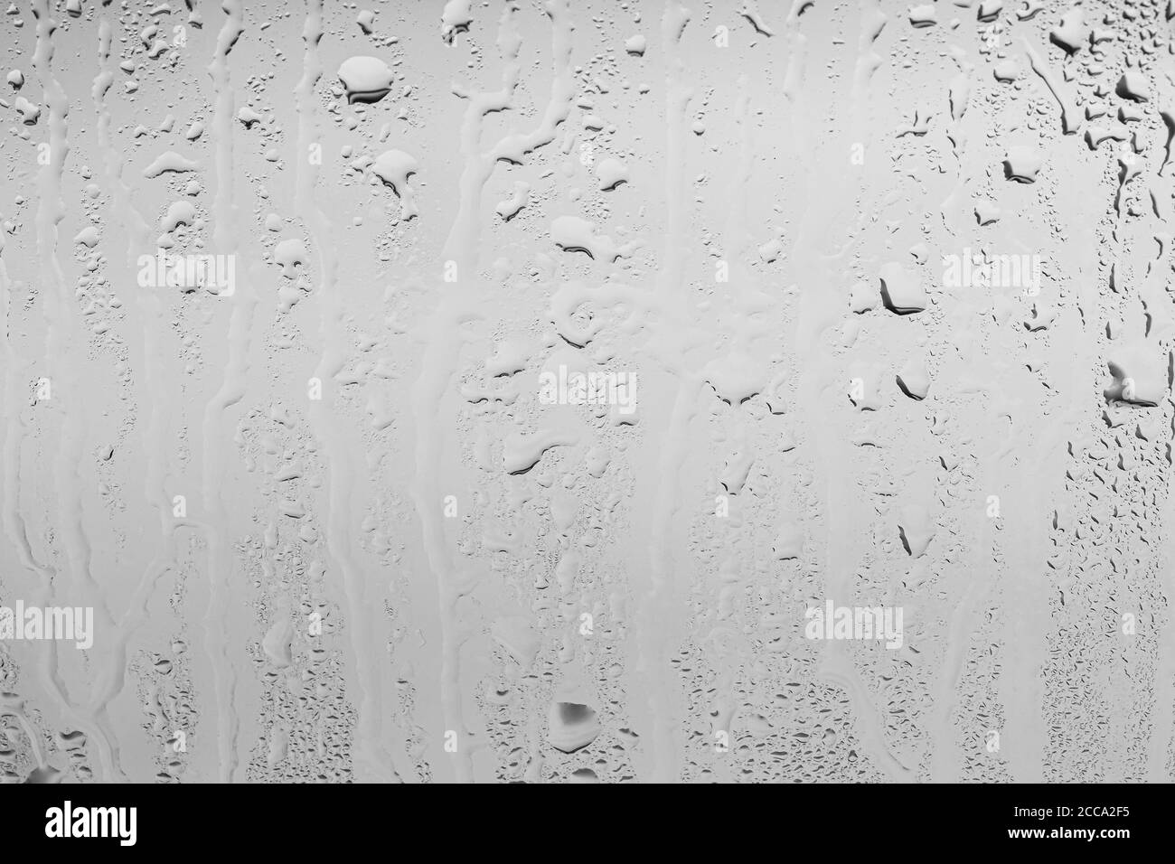 Rain drops on window glasses surface with gray sky background . Natural ...