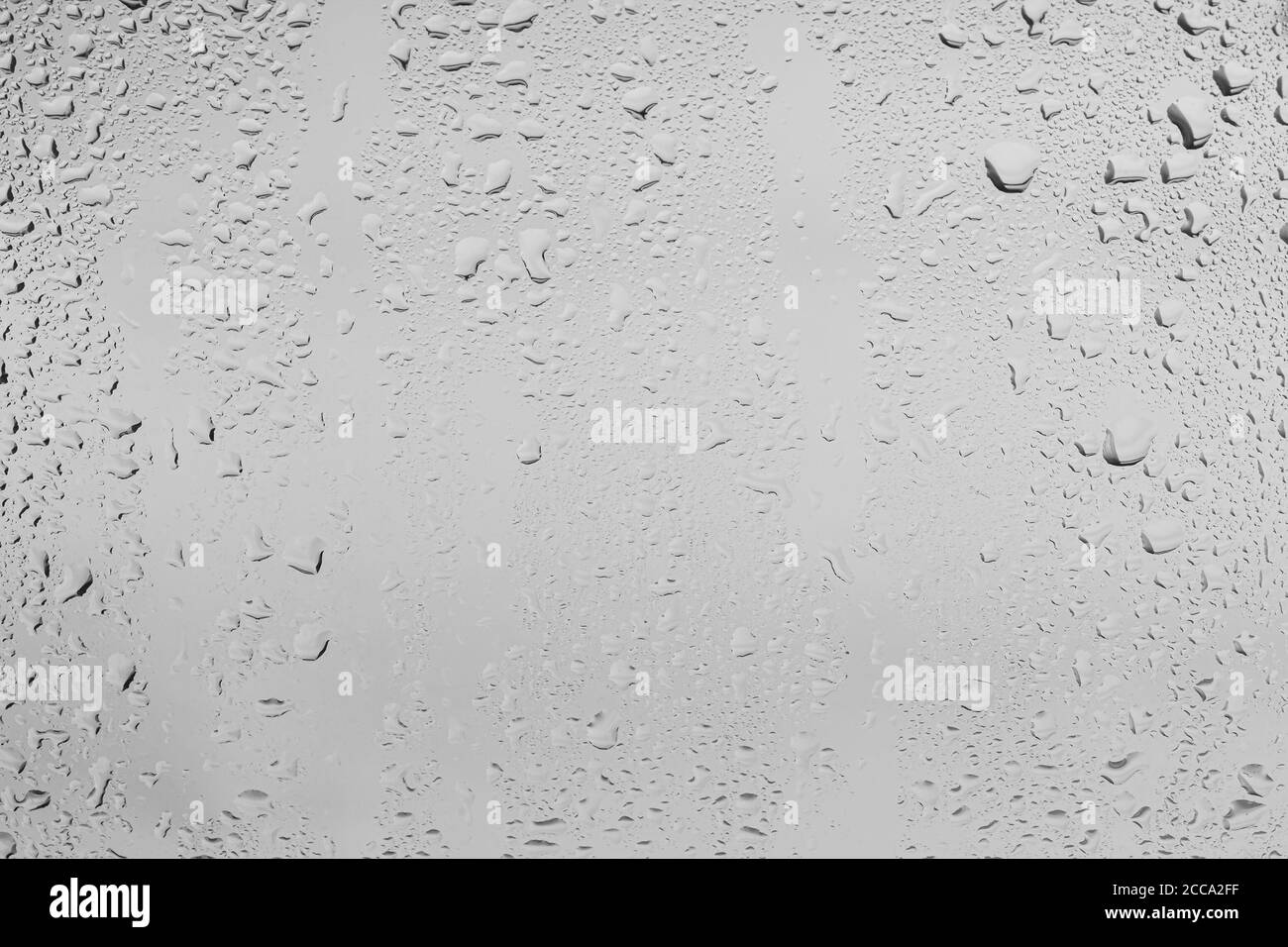 Rain drops on window glasses surface with gray sky background . Natural ...