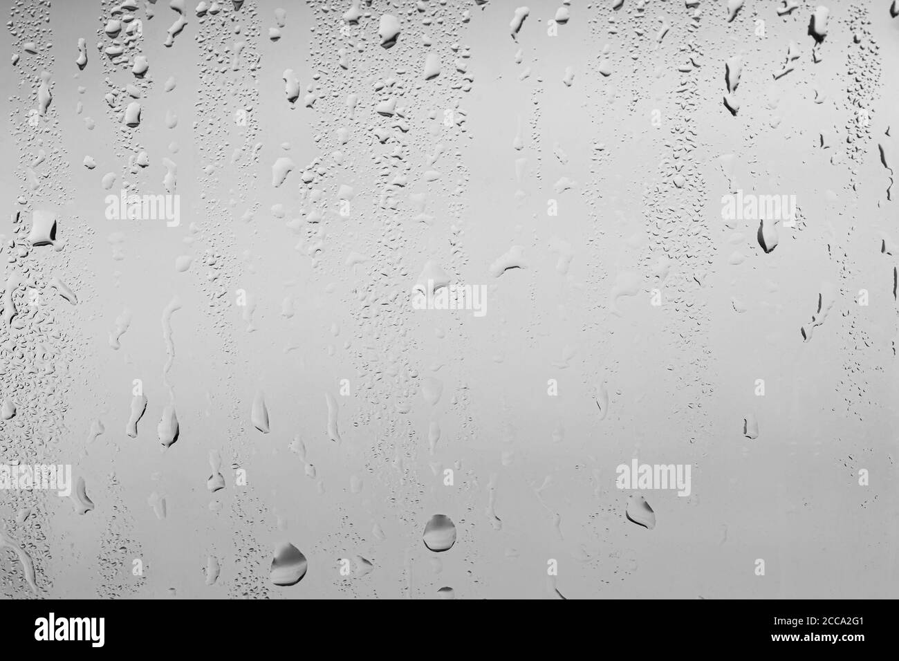 Rain drops on window glasses surface with gray sky background . Natural ...