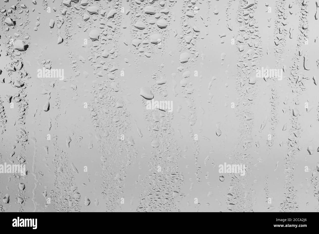 Rain drops on window glasses surface with gray sky background . Natural ...