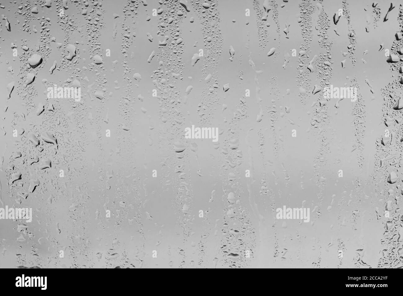 Rain drops on window glasses surface with gray sky background . Natural ...