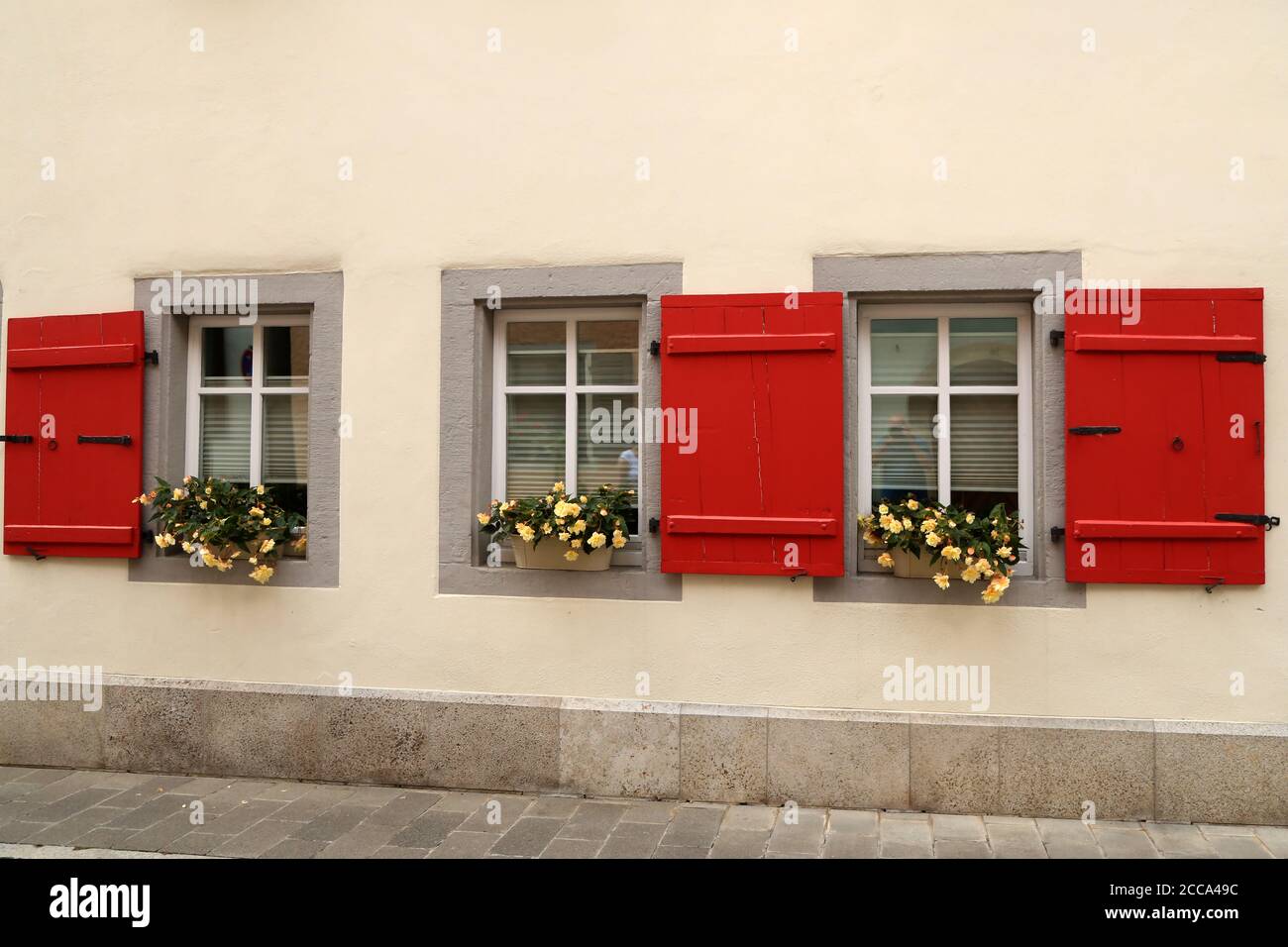 Beautiful flowers on the windows with shutters Stock Photo - Alamy