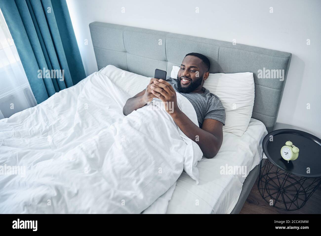 Positive delighted young man chatting with his friend Stock Photo - Alamy
