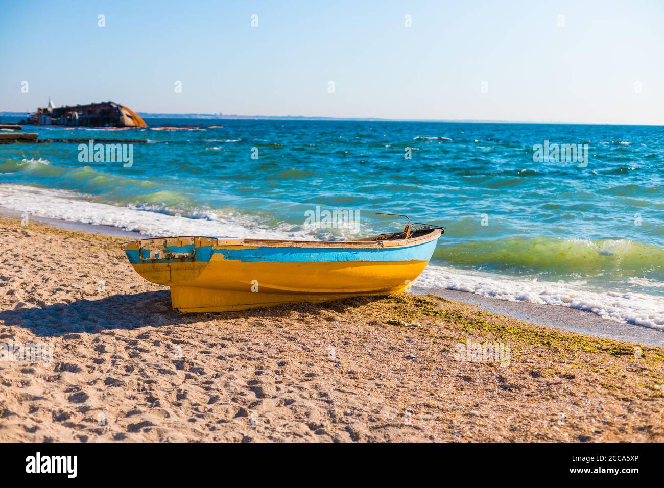 Beautiful seascape view with an old boat on the blue sea beach in sunny ...