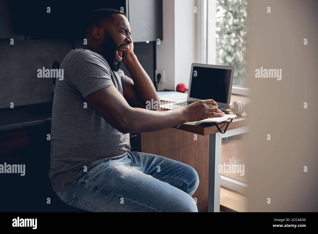 Bored student yawning while listening to the lecture Stock Photo - Alamy