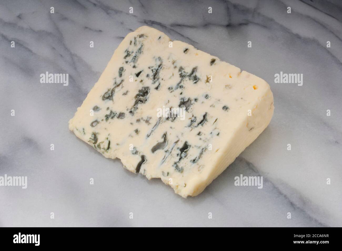 Studio shot of a slice of blue cheese resting on a marble slab - John ...
