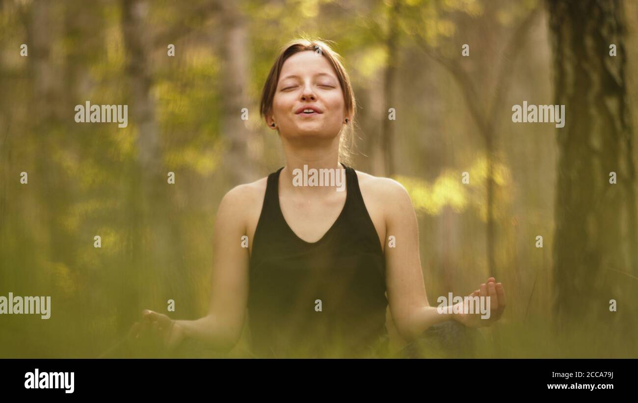 Woman sitting namaste yoga pose in spiritual relaxation serenity and ...