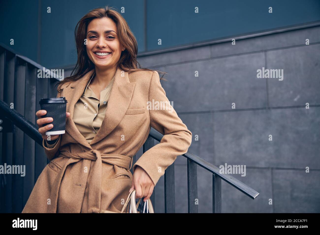 Smiling woman leaning back against the rail Stock Photo - Alamy