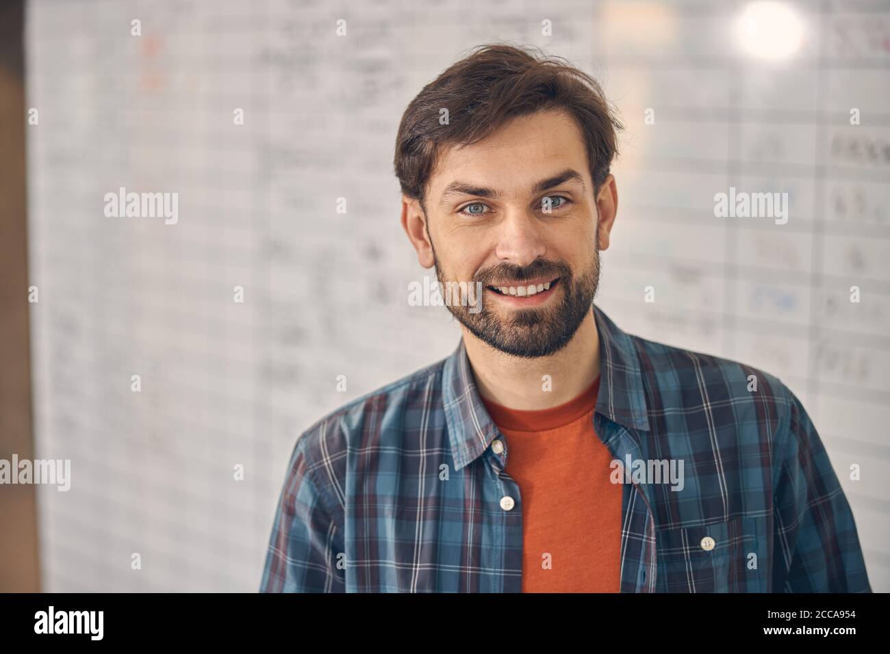 Handsome young man looking at camera and smiling Stock Photo - Alamy