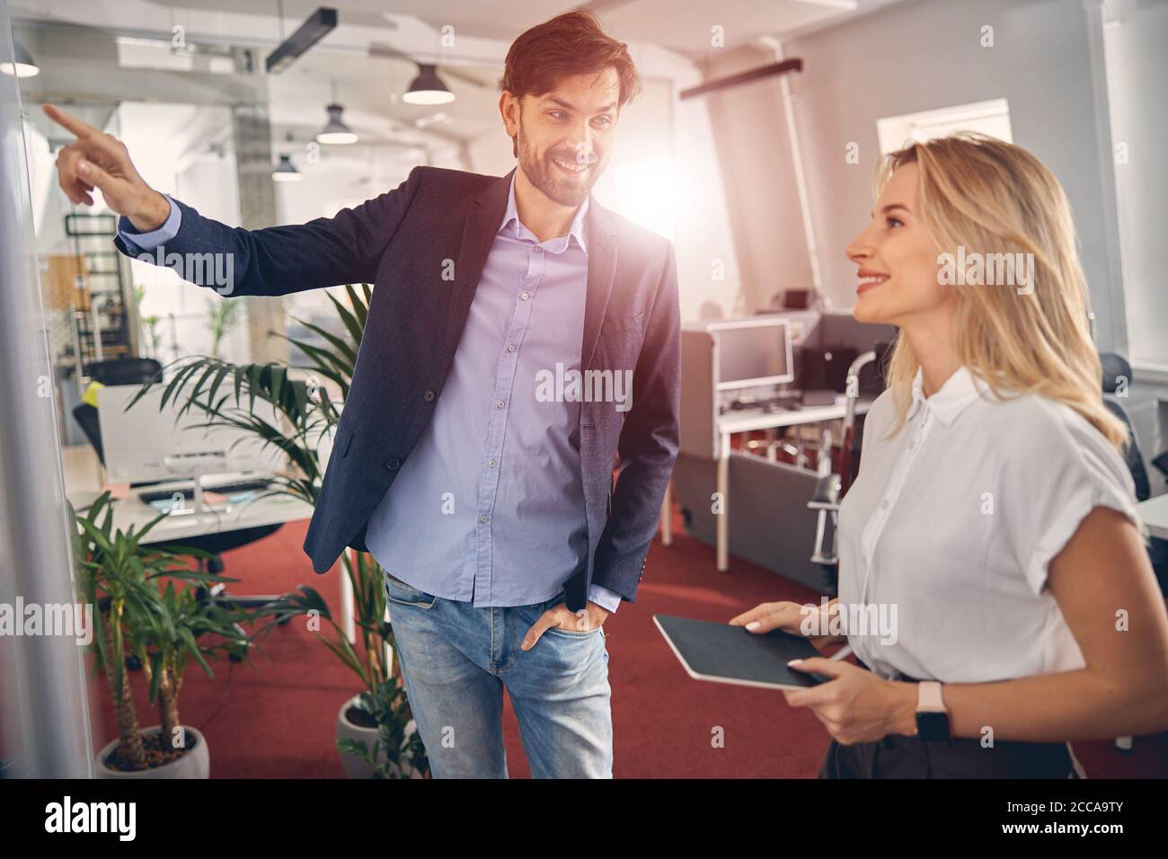 Joyful business colleagues discussing project at work Stock Photo - Alamy