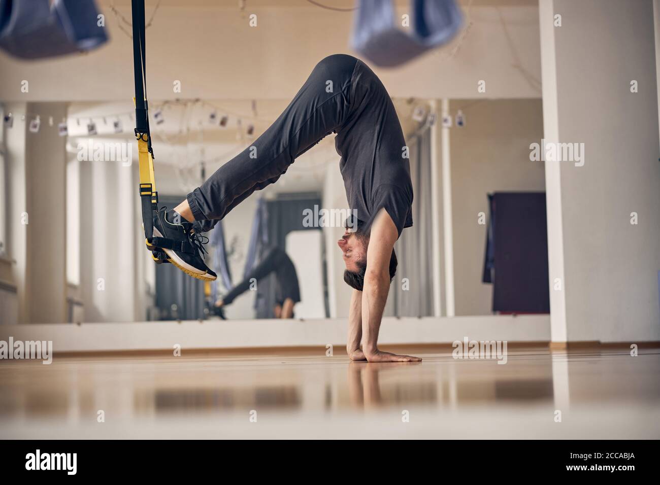 Serious young man is doing suspended pike Stock Photo - Alamy