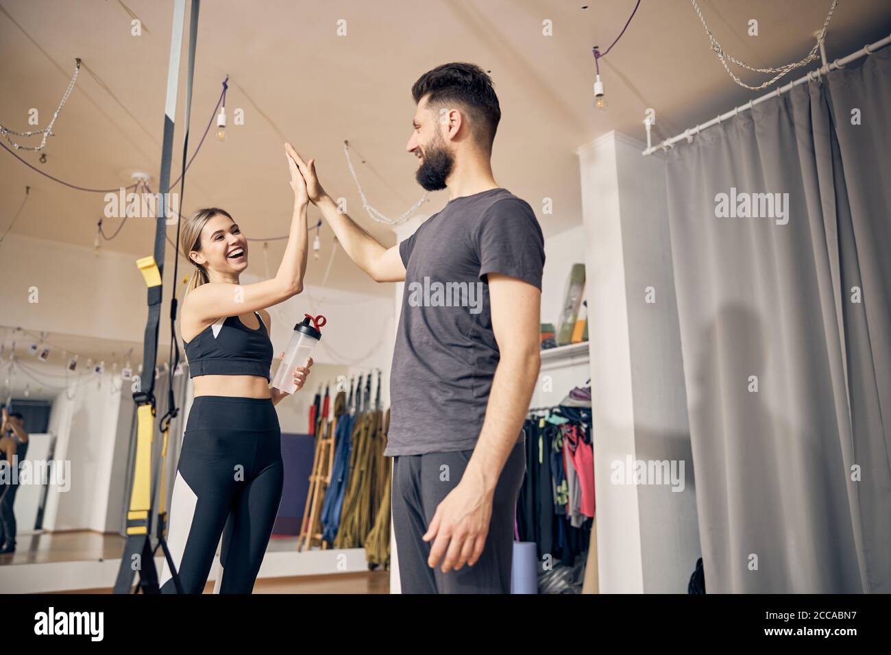 Female athlete and her trainer slapping hands Stock Photo - Alamy