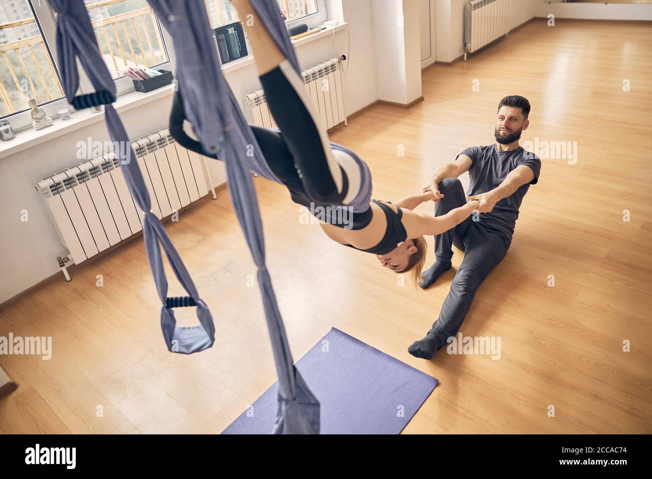 Sporty lady doing exercise with instructor in studio Stock Photo - Alamy