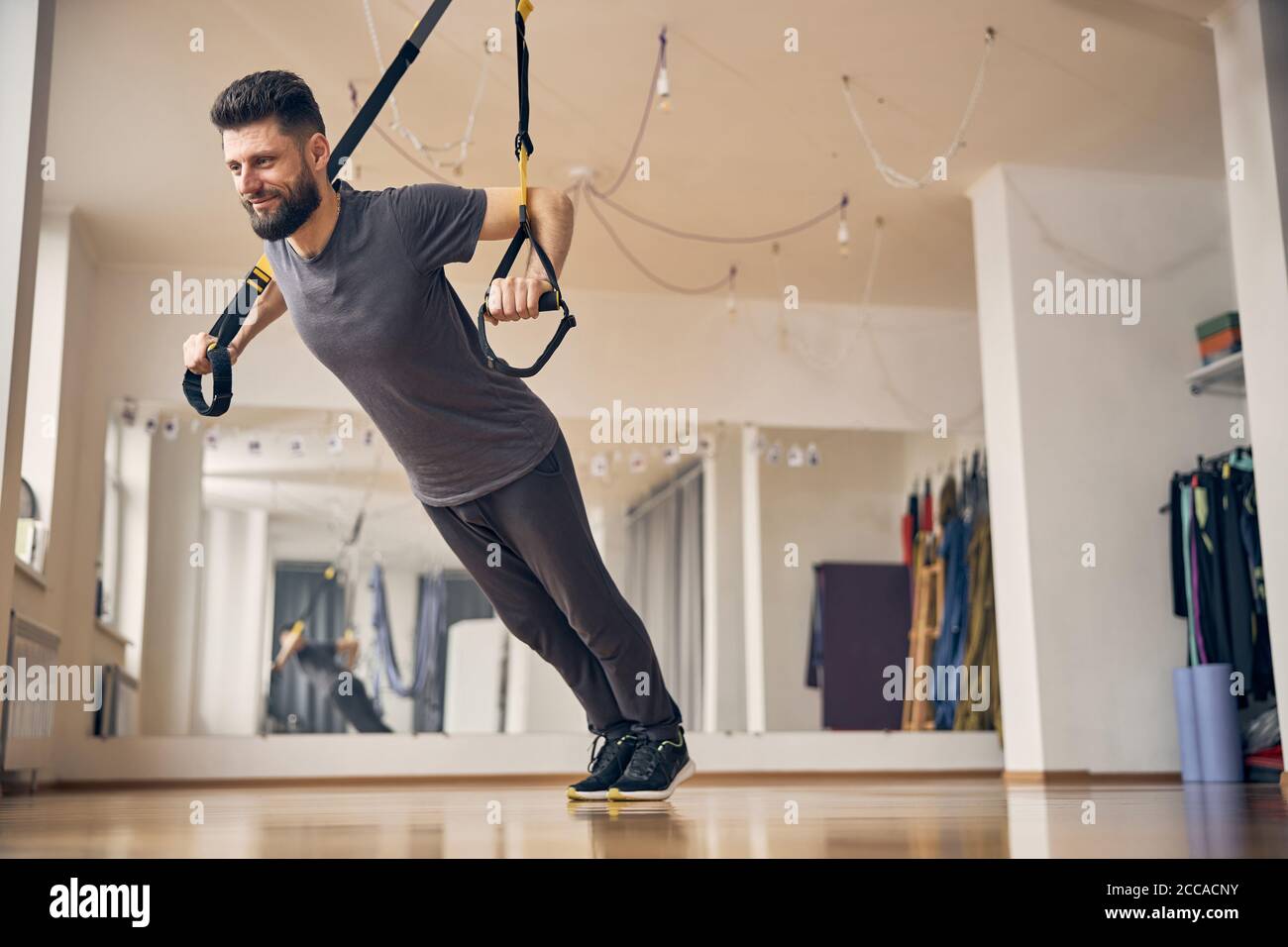 Smiling man performing a strength training exercise Stock Photo - Alamy