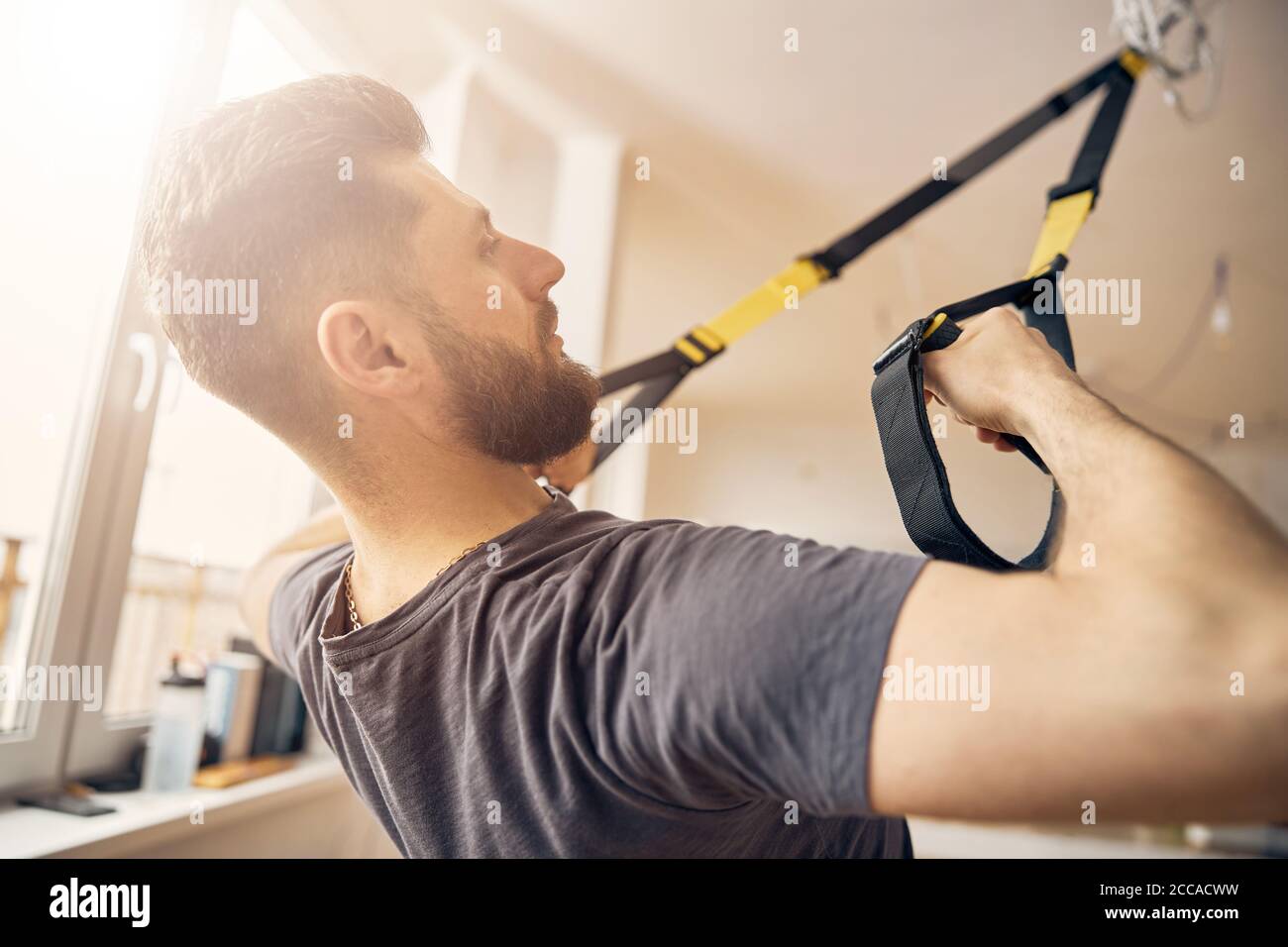 Athletic male doing a TRX row exercise Stock Photo - Alamy