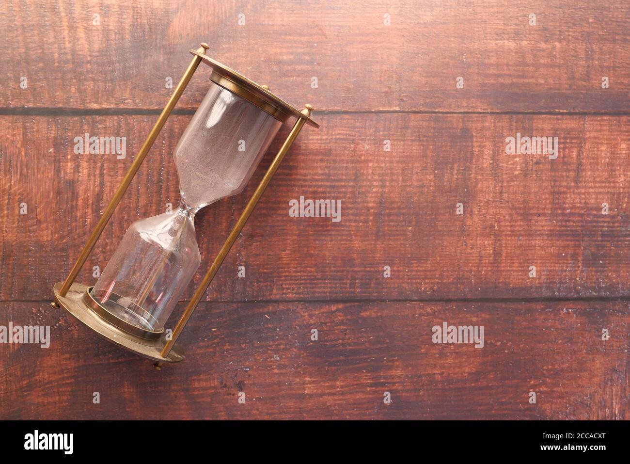 hourglass on table, sand flowing through the bulb of sandglass Stock ...