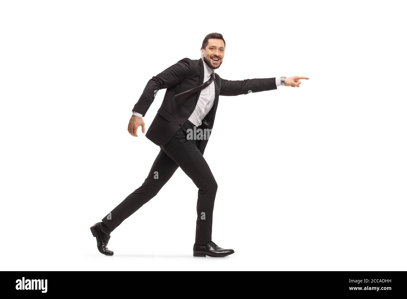 Handsome man in a black suit running and pointing isolated on white ...