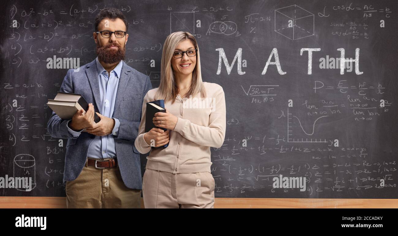 Male and female math teacher in front of a blackboard with text and ...