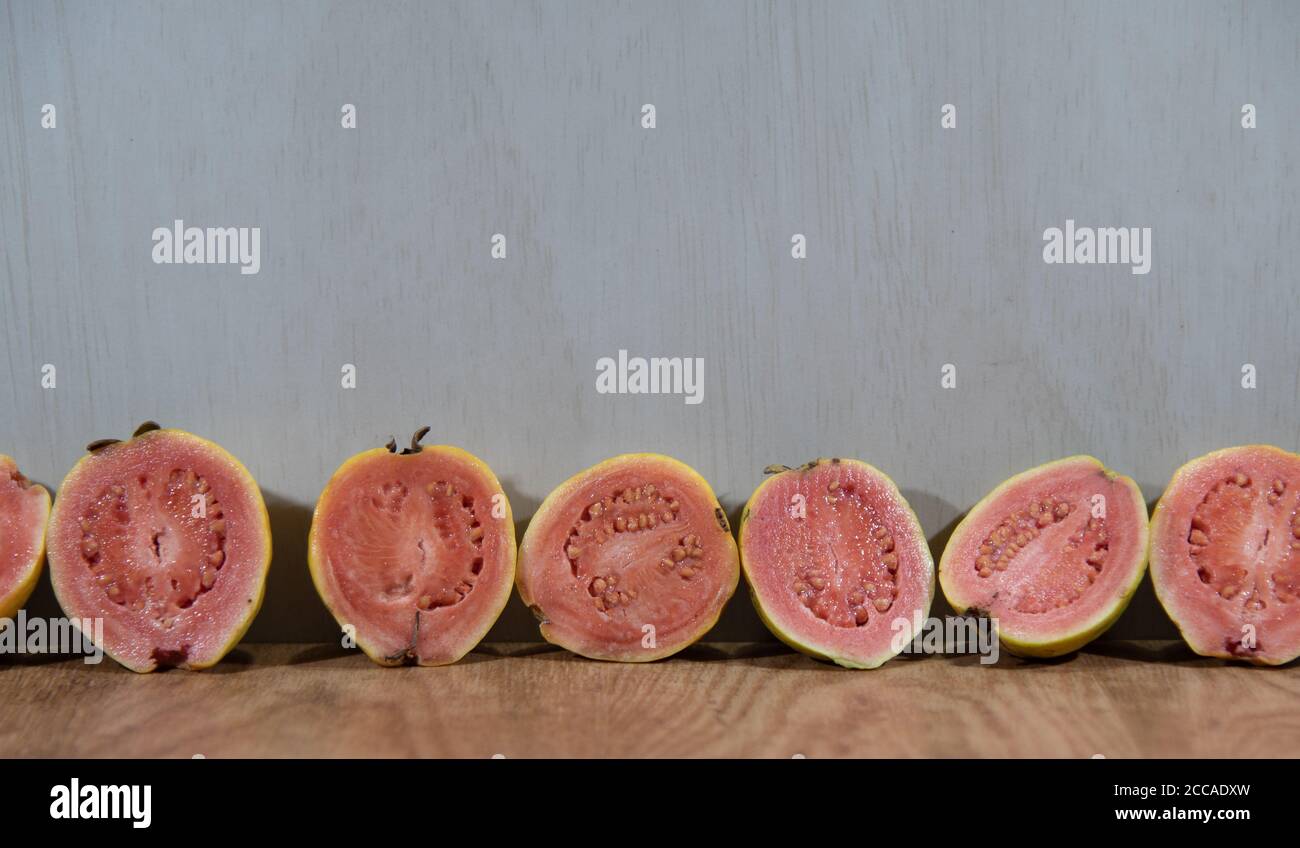 Guava fruits broken in half. Tropical fruits. Guavas in halves. Source ...