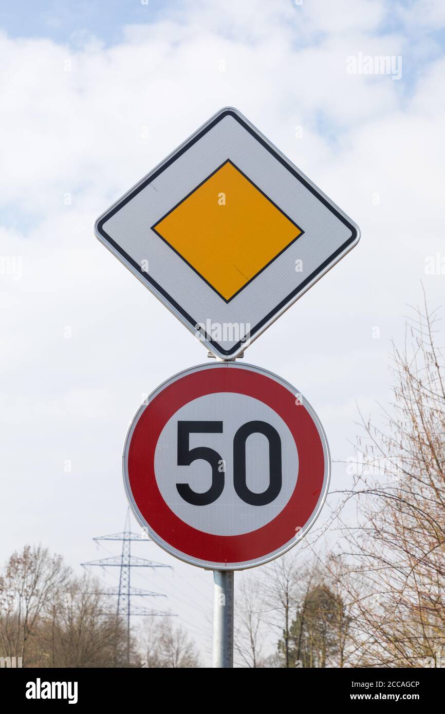 Vertical low angle shot of the traffic sign for priority road and speed ...