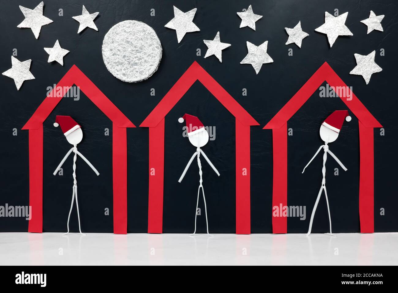 Three stick man figure wearing santa hat alone inside a red house ...