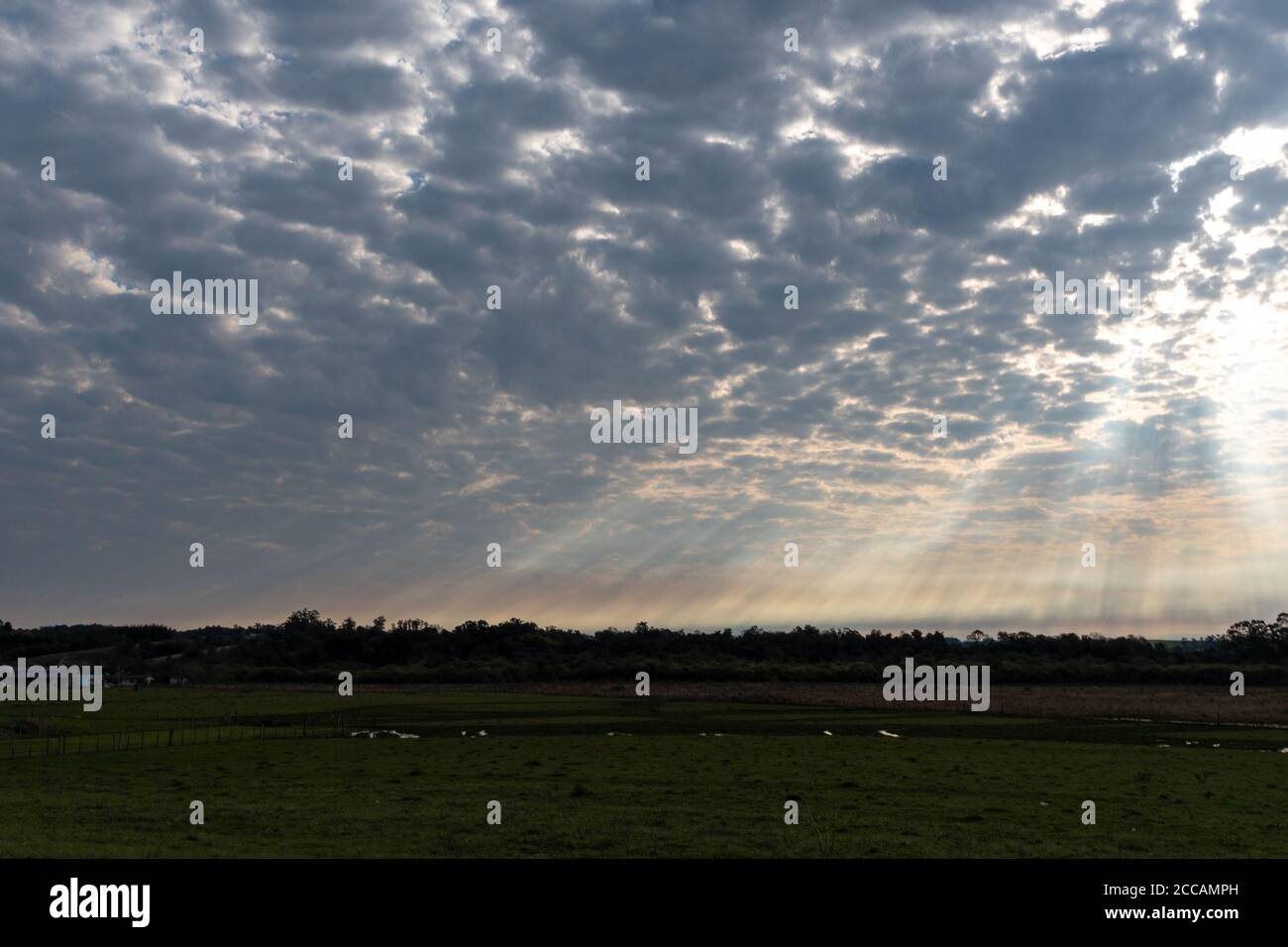 Late afternoon landscape with the sun setting over the horizon of the ...