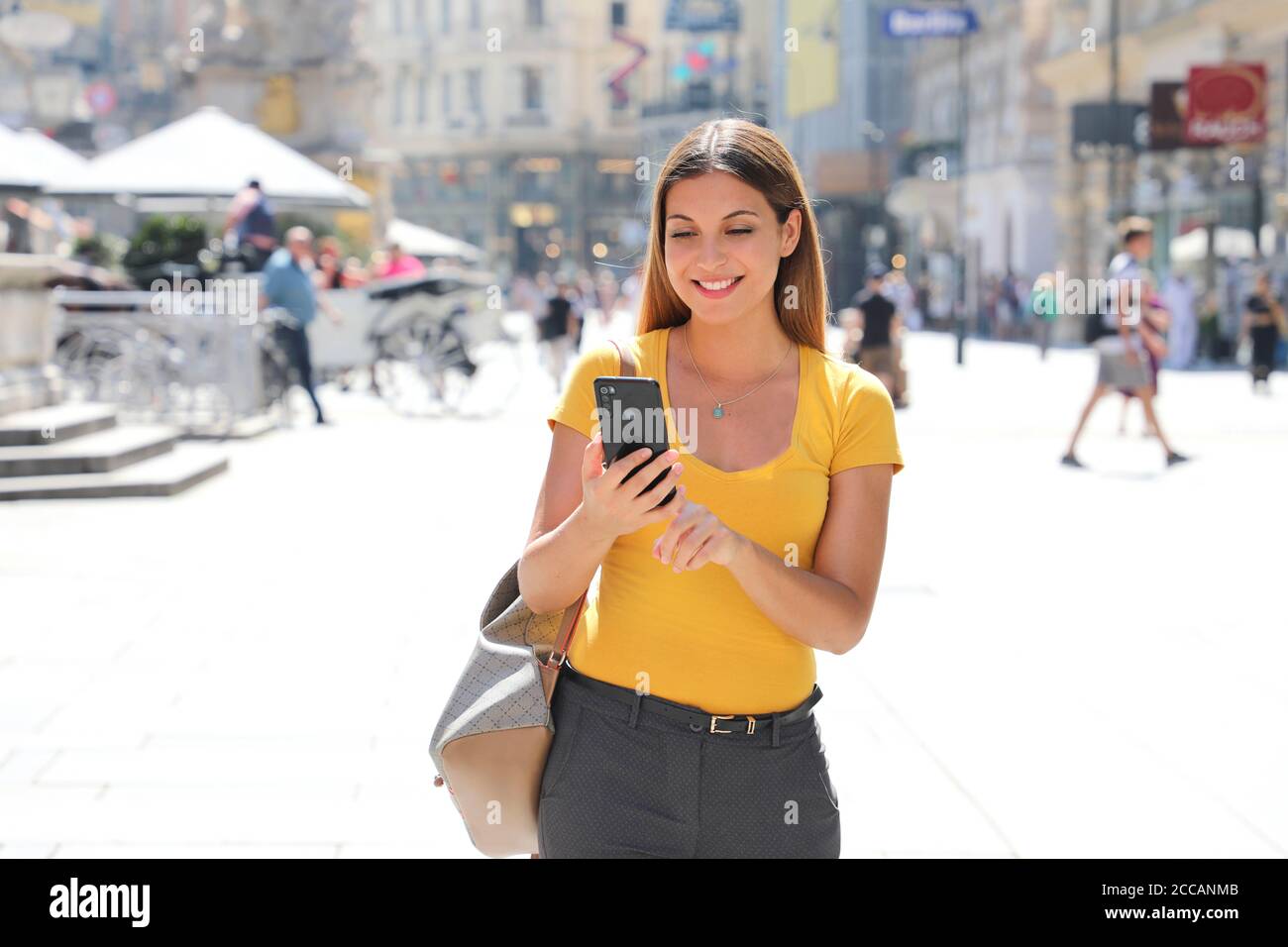 Mobile looking woman walking typing hi-res stock photography and images ...