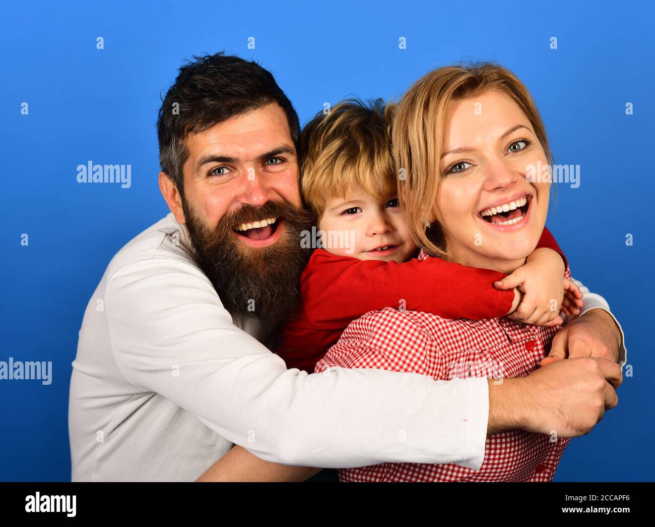 Kid sitting on moms back. Man with beard, woman and son happy together ...