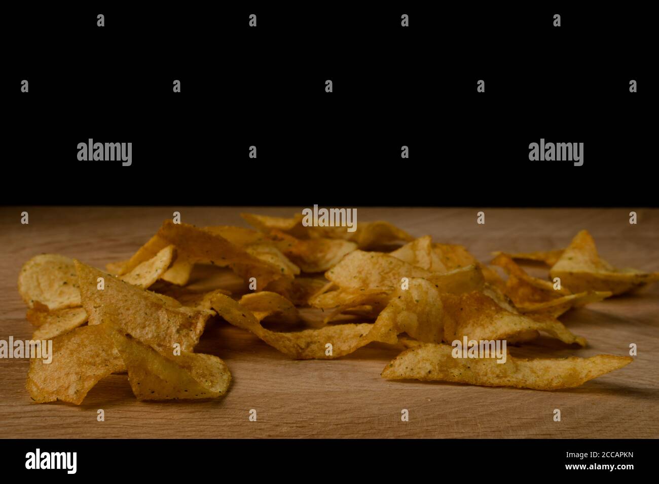 Appetizing potato chips are scattered on a wooden board Stock Photo - Alamy