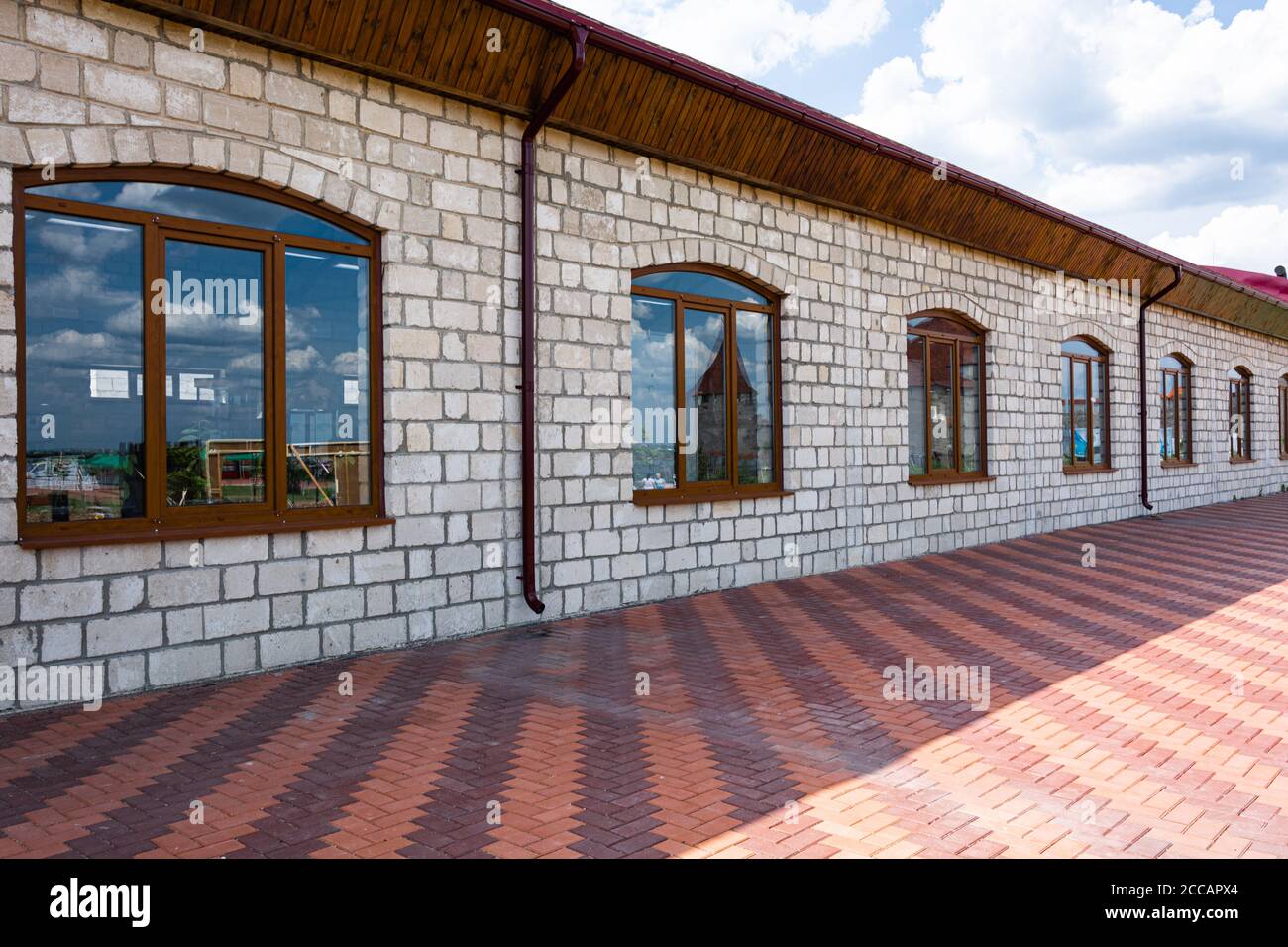 Colored red paving slabs and brown pvc metal-plastic windows ...