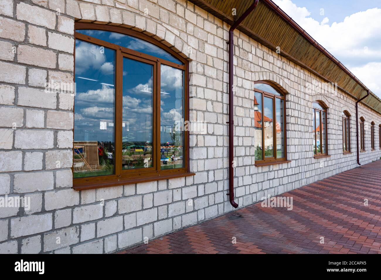 Colored red paving slabs and brown pvc metal-plastic windows ...