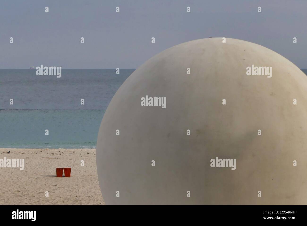 Winter beach. Round architectural structure and trash bins. Minimalism ...