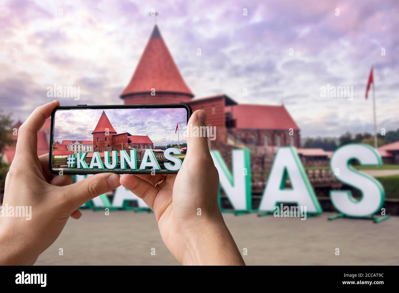 Tourist taking photo of view of Kaunas castle and word Kaunas during ...