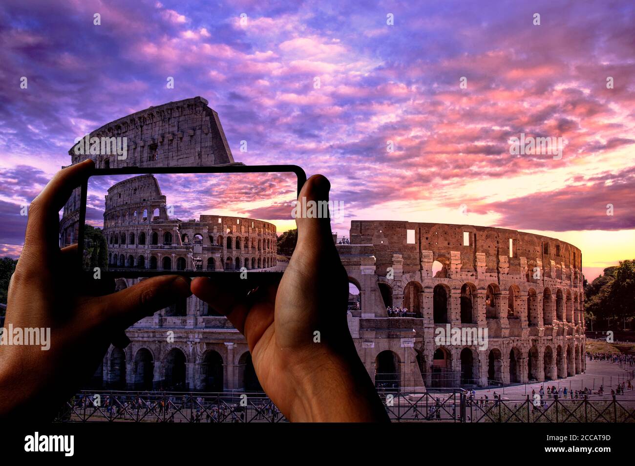 Tourist taking photo of Colosseum (Coliseum) in Rome at sunset against ...
