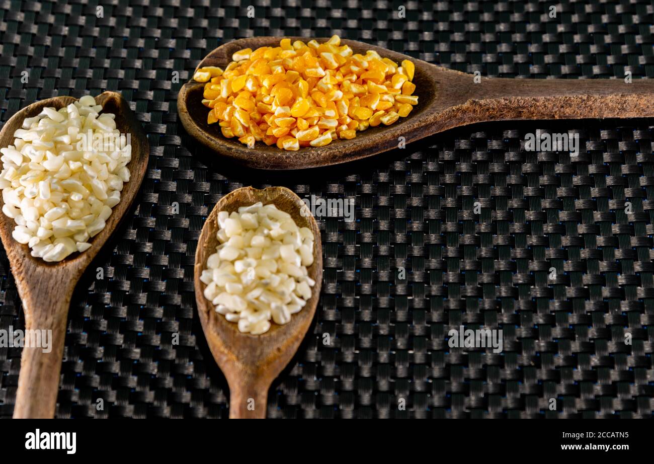 Corn seeds for hominy preparation. Hominy in yellow and white in wooden ...