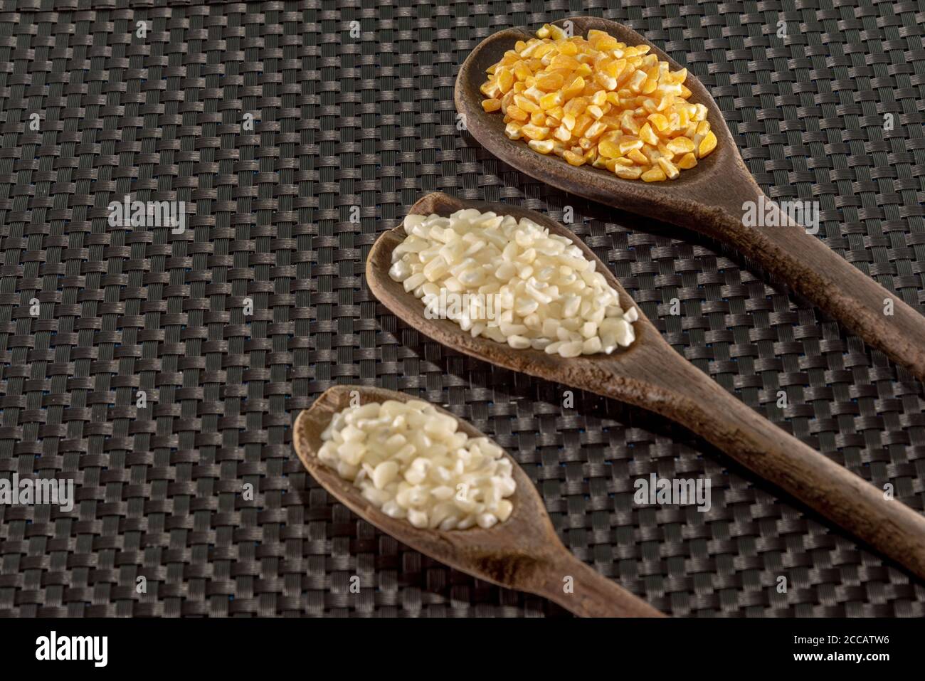 Corn seeds for hominy preparation. Hominy in yellow and white in wooden ...